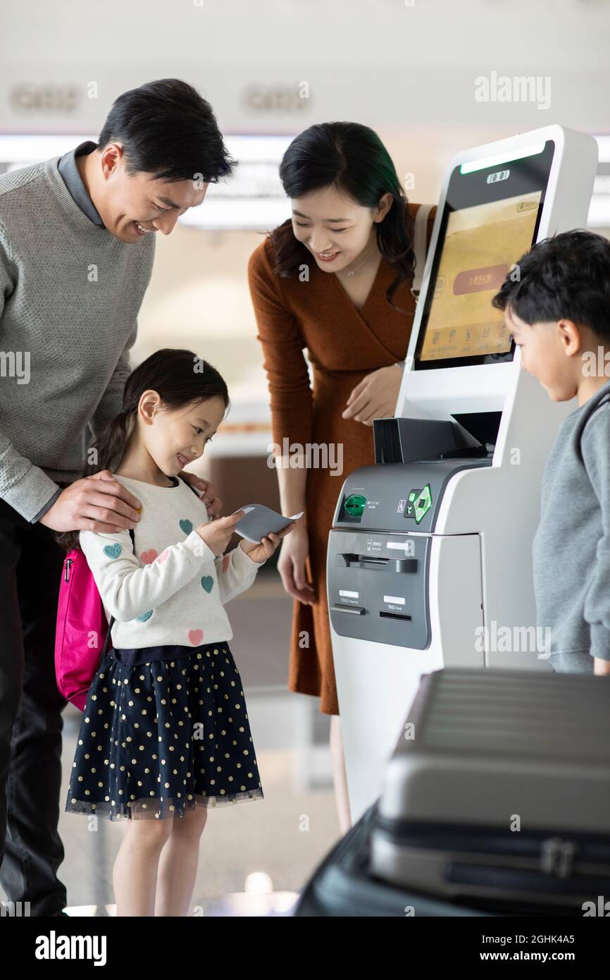 Happy young family doing self check-in at airport Stock Photo - Alamy