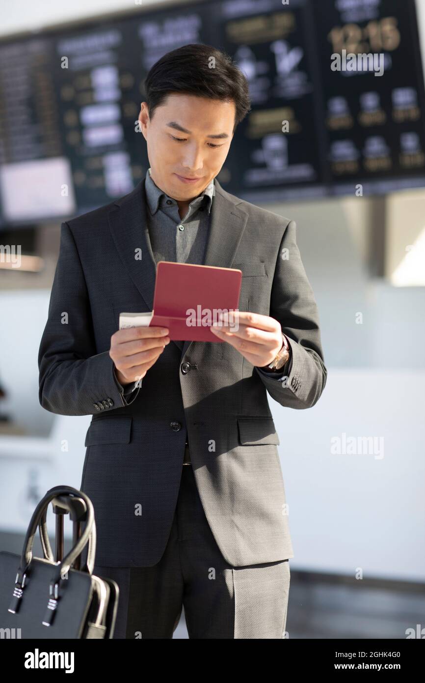 Successful businessman with airplane ticket at airport Stock Photo - Alamy
