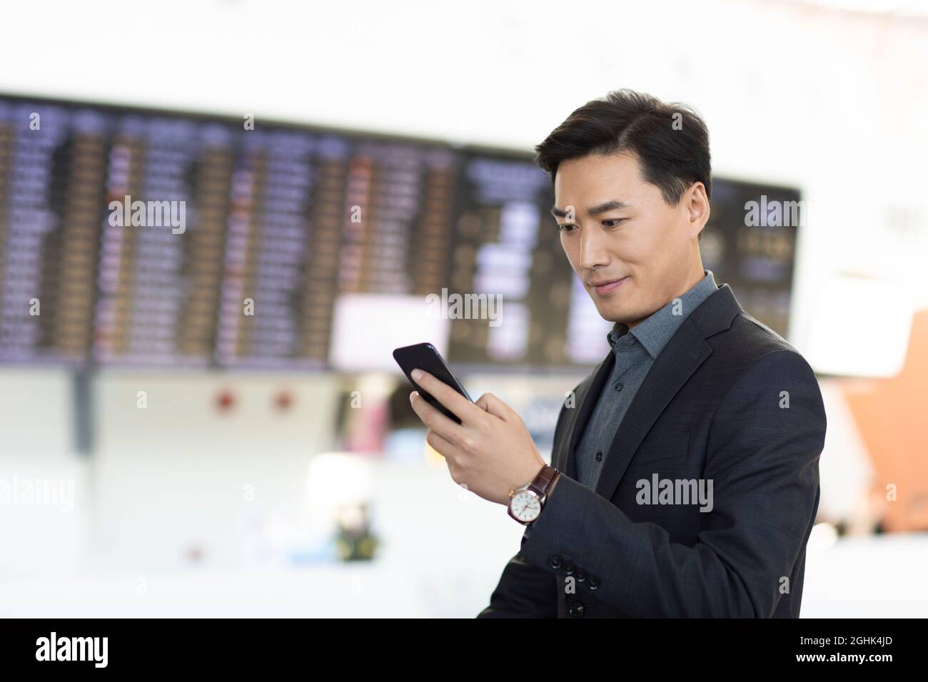 Successful businessman using smartphone at airport Stock Photo - Alamy