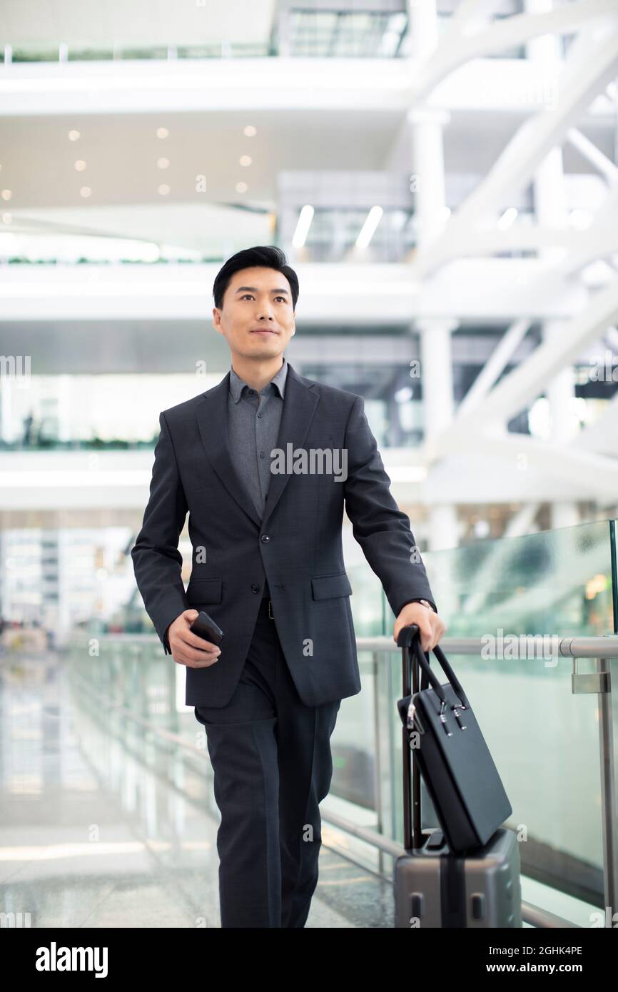Successful businessman with luggage at airport Stock Photo - Alamy