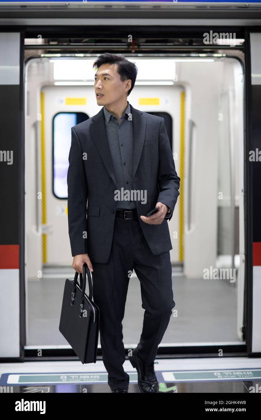 Successful businessman getting off subway in subway station Stock Photo ...