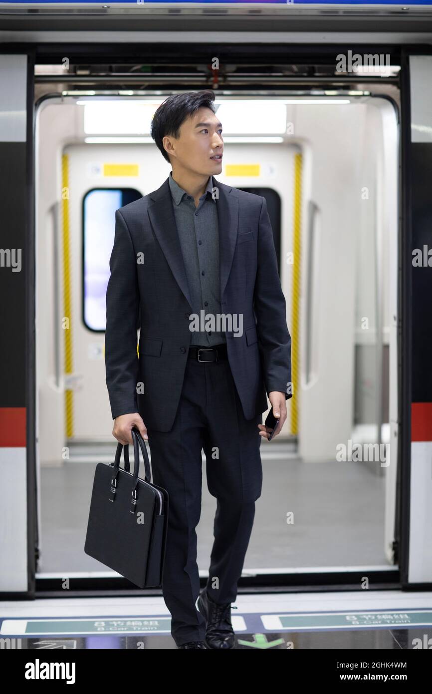 Successful businessman getting off subway in subway station Stock Photo ...