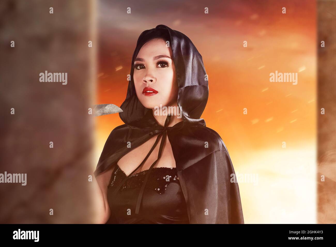 Asian witch woman with a cloak holding a knife standing with dramatic ...