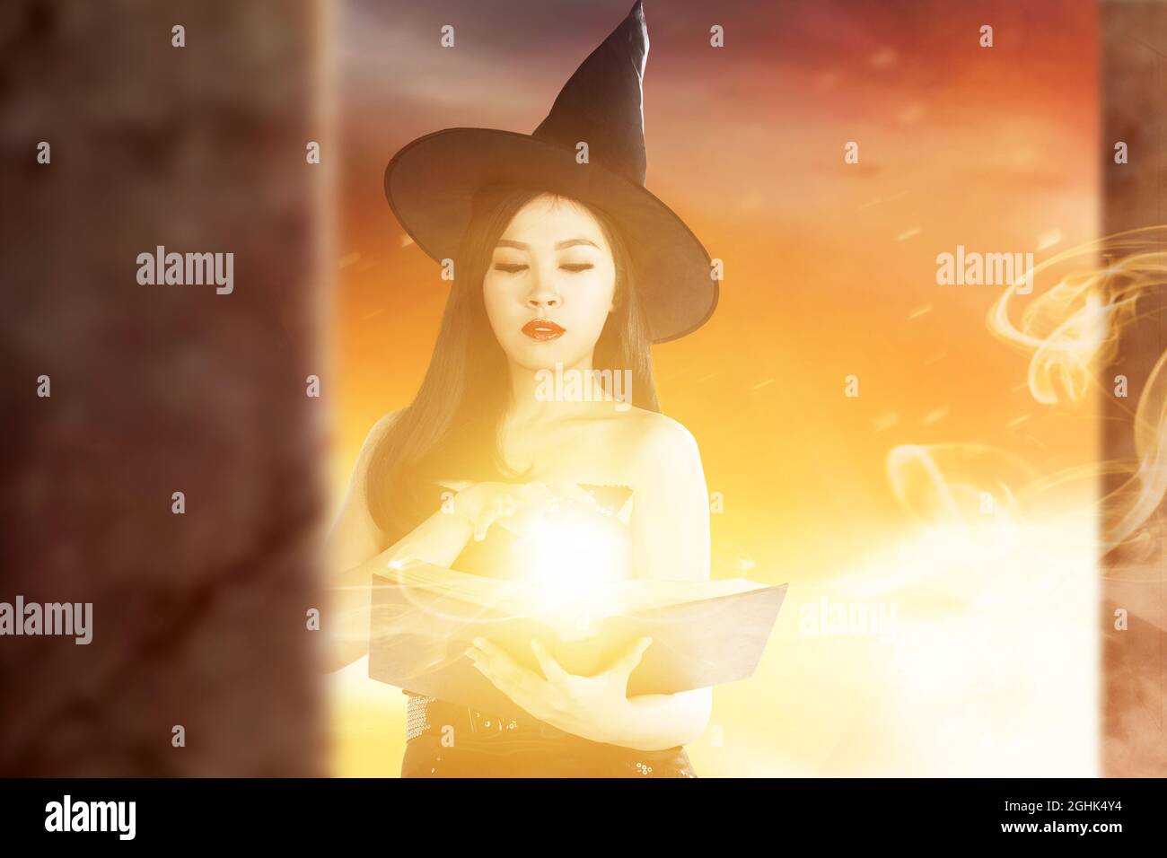 Asian witch woman with spellbook showing magic on her hand with ...