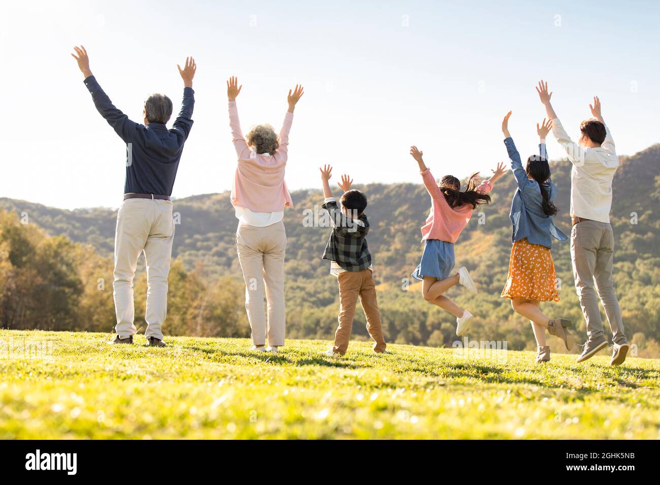 Happy family relaxing on meadow Stock Photo - Alamy