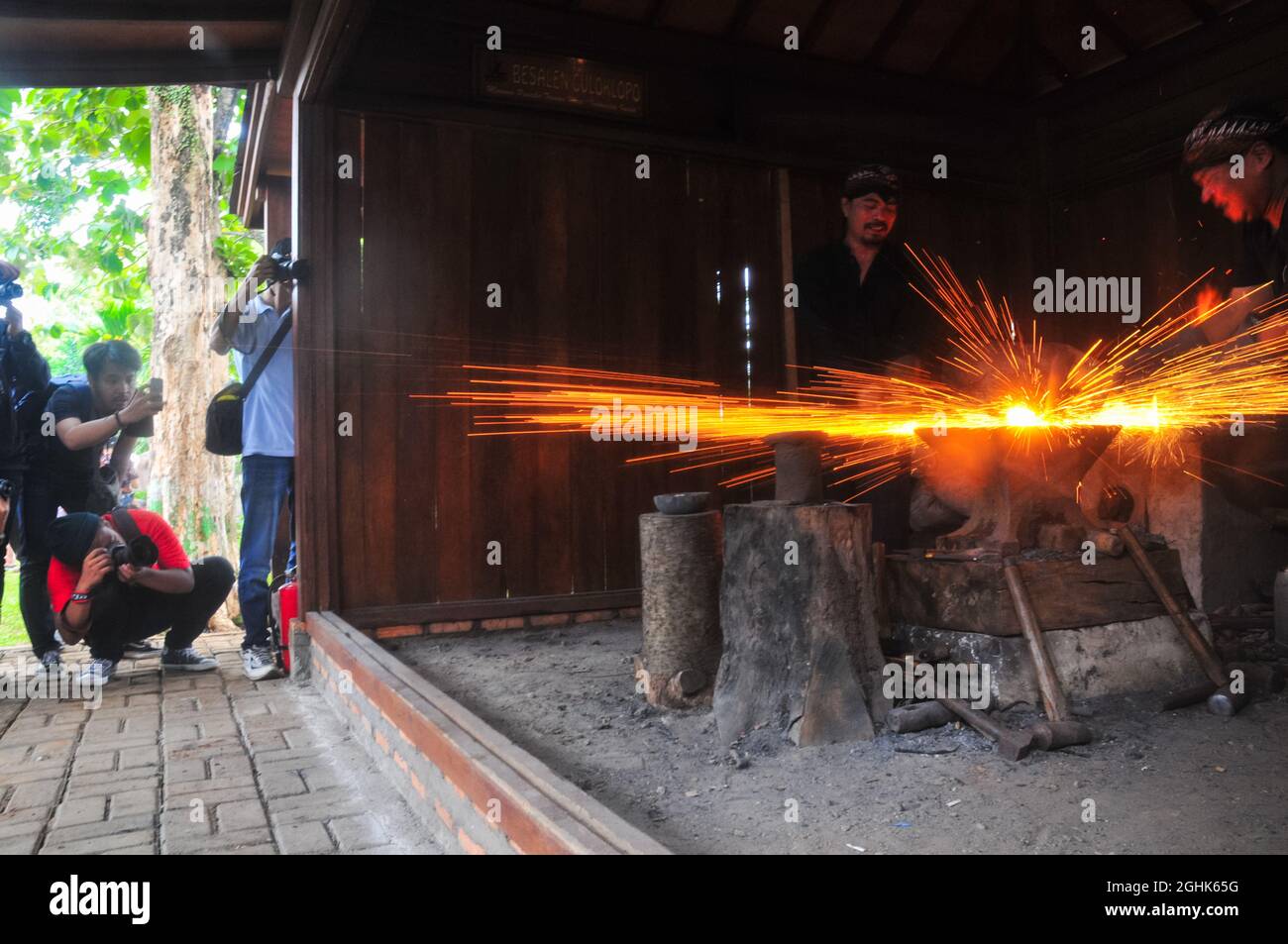Photographers are photographing two blacksmiths or mpu keris, forging ...
