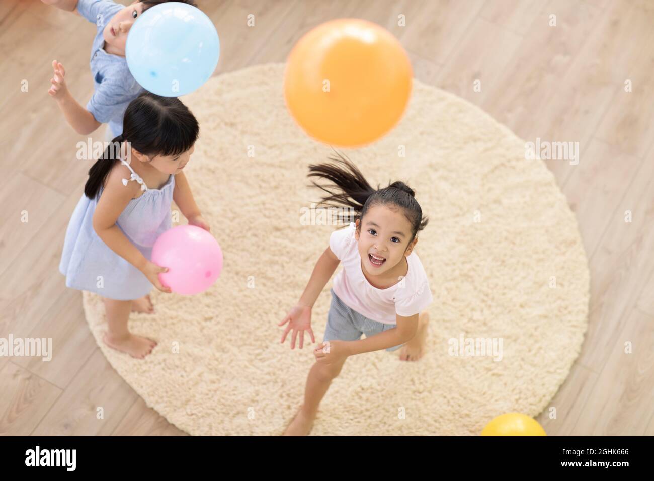 Cute children playing with balloons in living room Stock Photo - Alamy