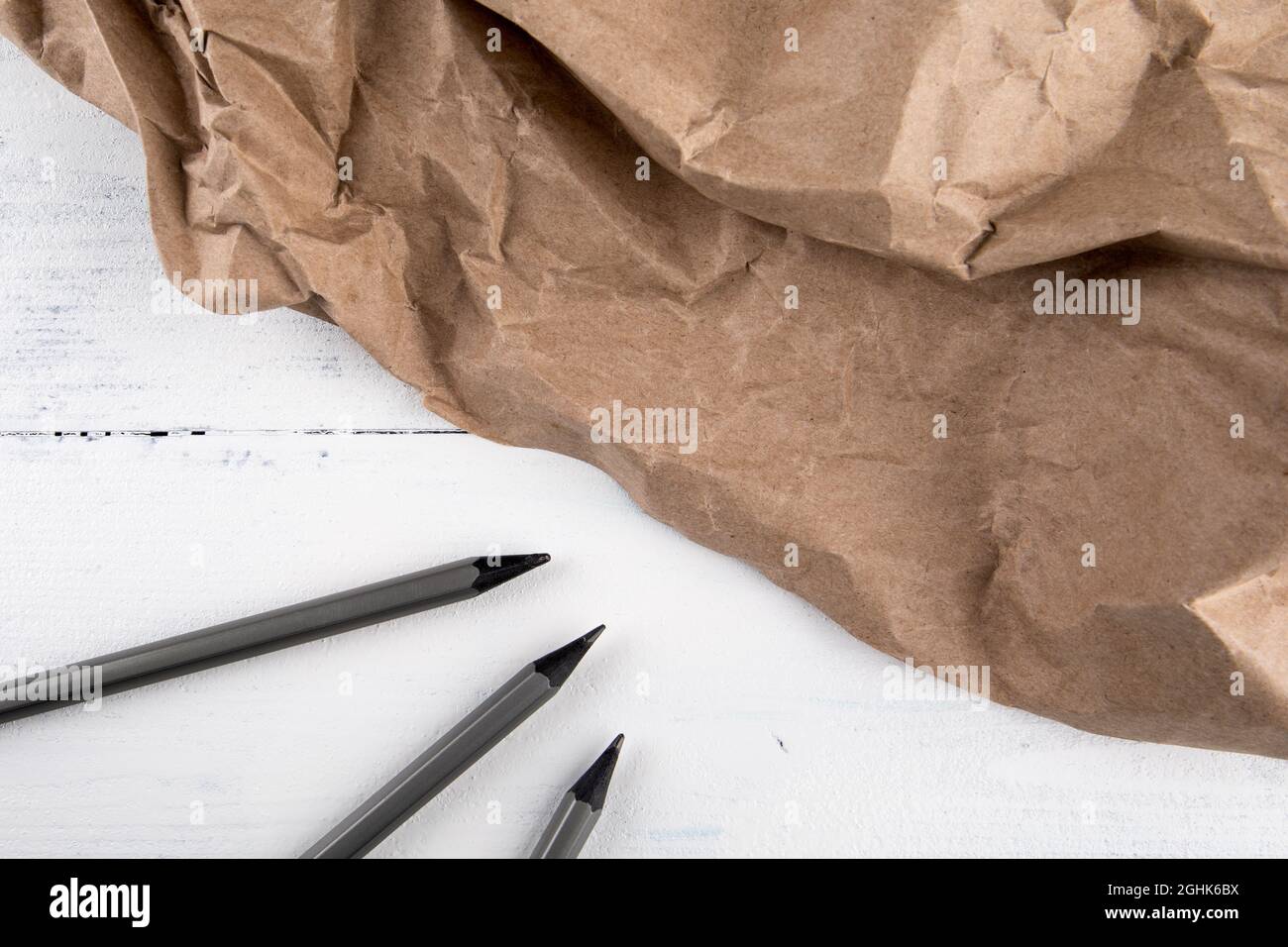 Crumpled cardboard wrapping paper and pencils on the table Stock Photo ...