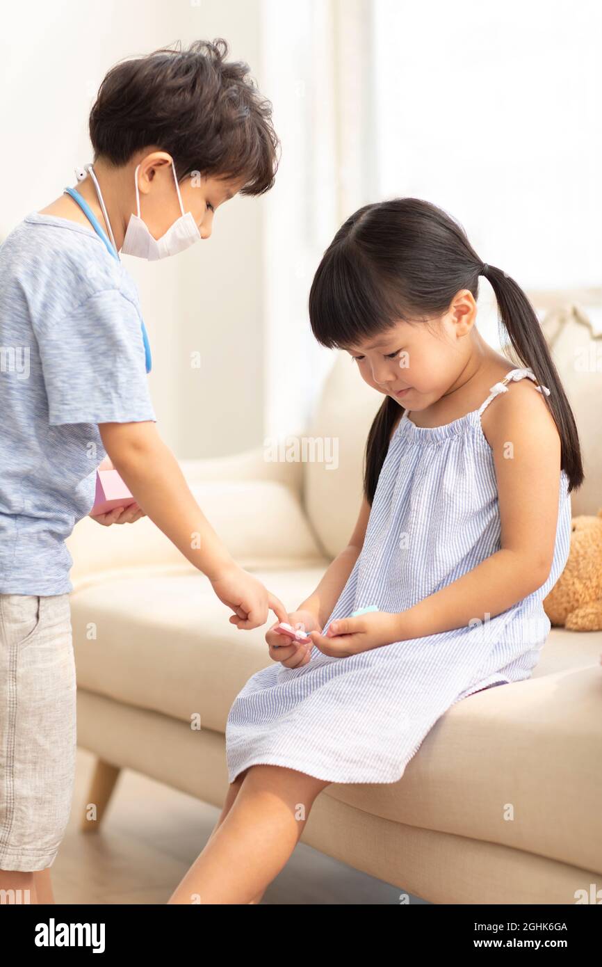 Cute boy playing doctor in living room Stock Photo - Alamy