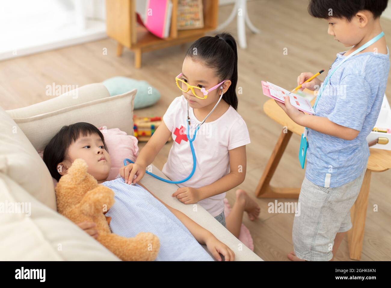 Cute girl playing doctor in living room Stock Photo - Alamy