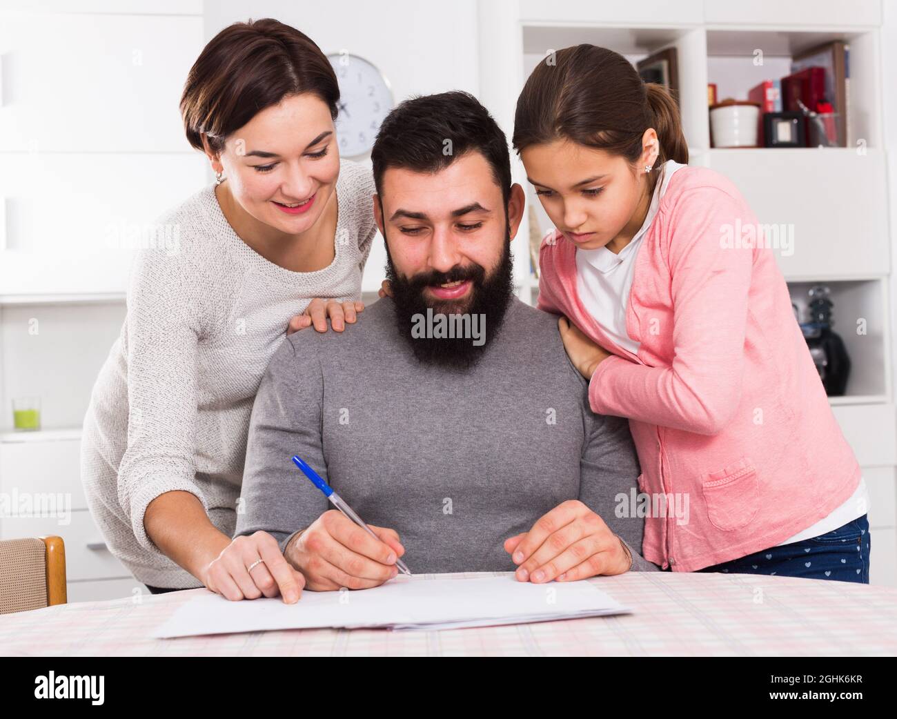Parents signing property papers Stock Photo - Alamy