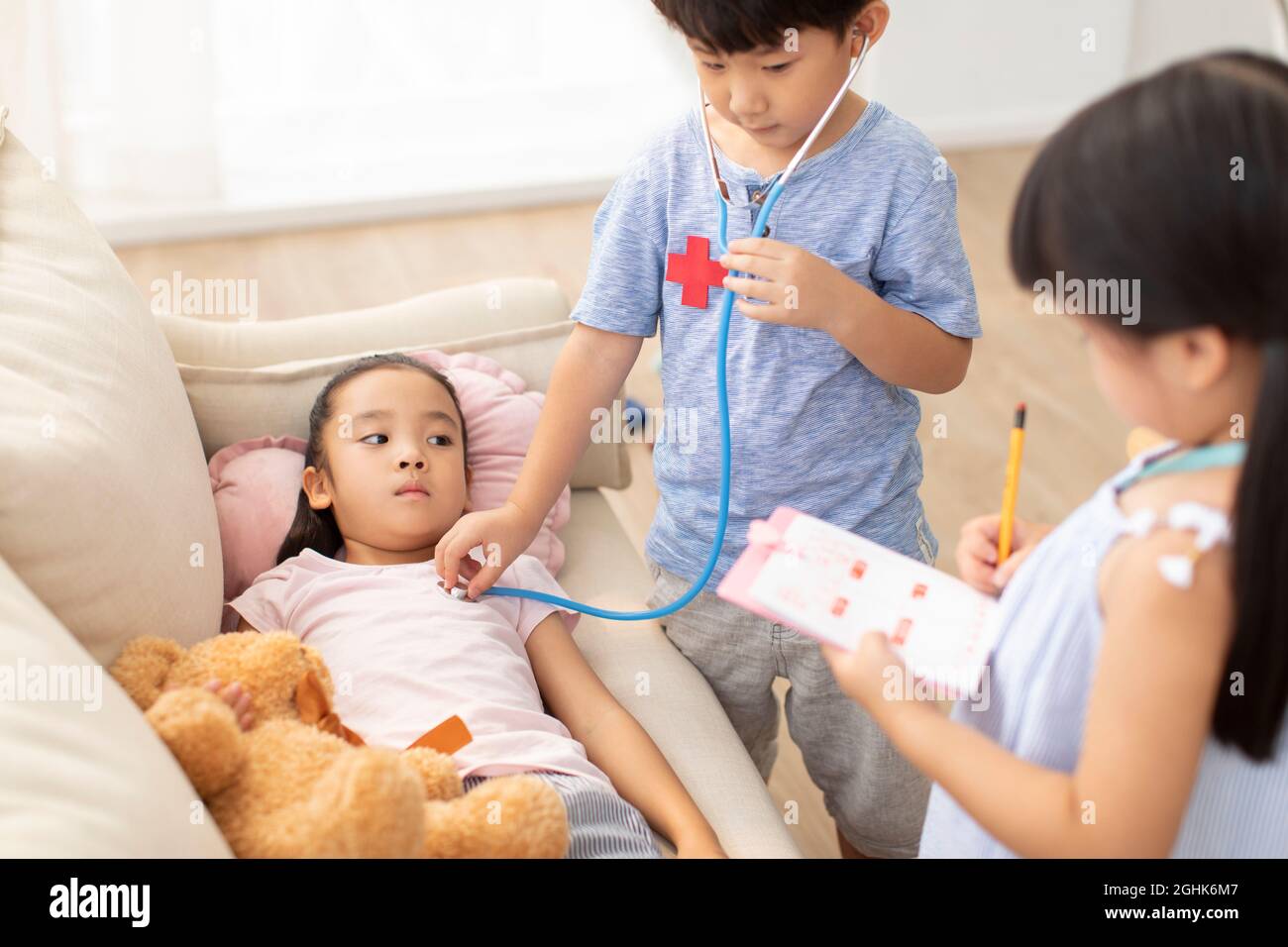 Cute boy playing doctor in living room Stock Photo - Alamy