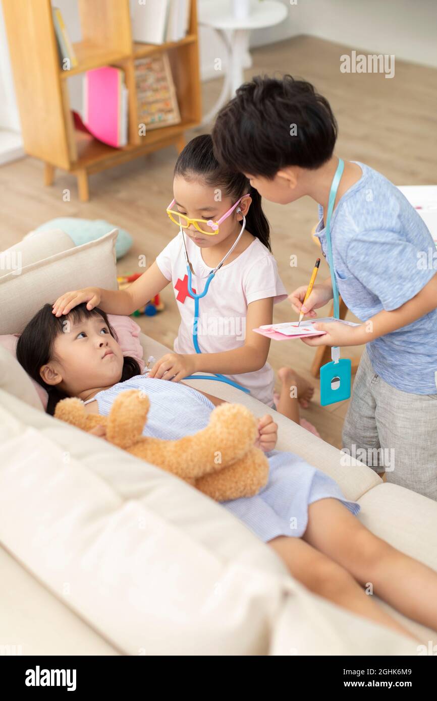 Cute girl playing doctor in living room Stock Photo - Alamy