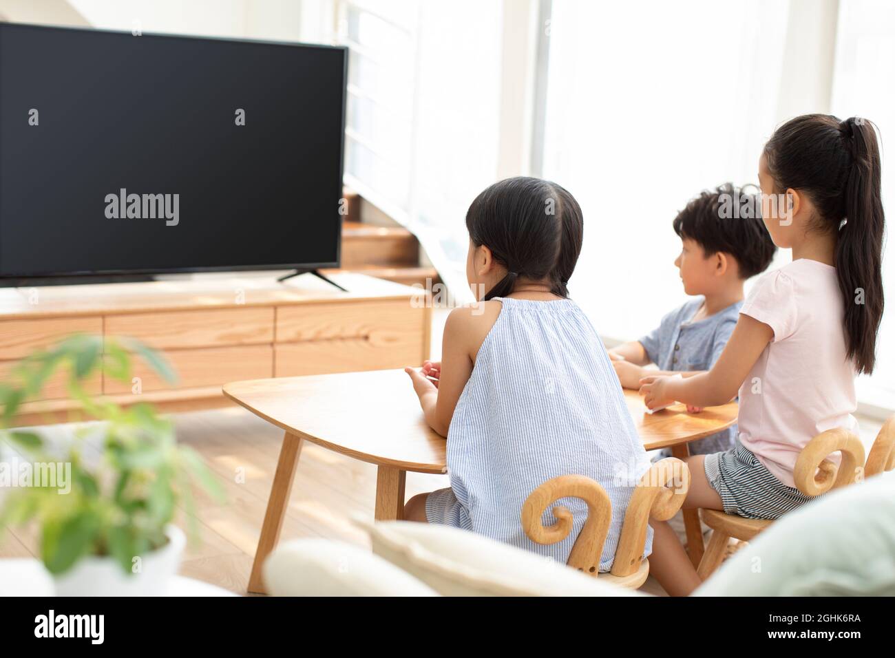 Cute children watching TV in living room Stock Photo - Alamy