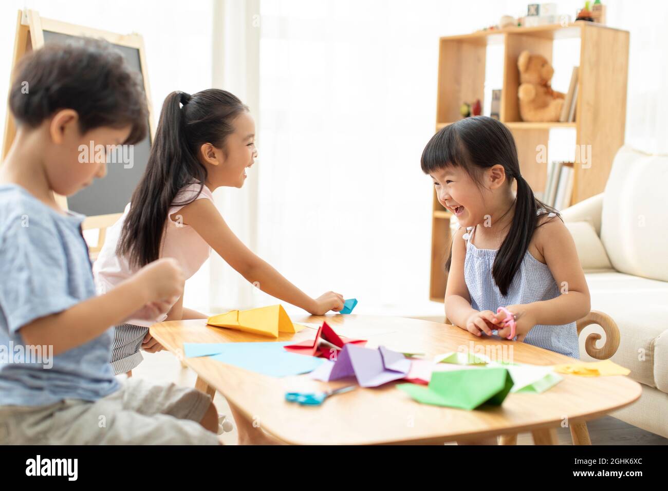 Cute children doing paper craft in living room Stock Photo - Alamy