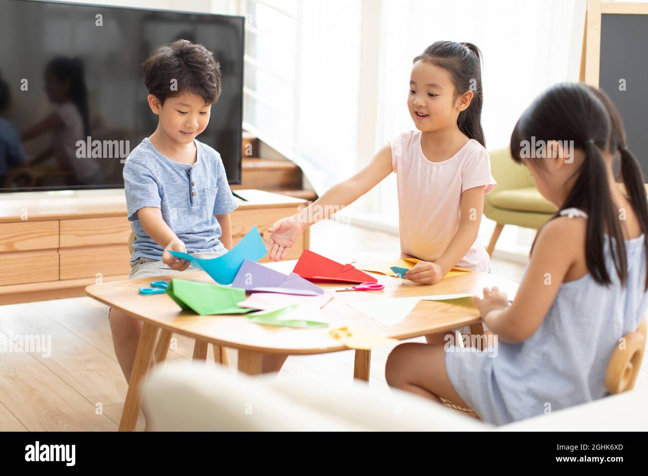 Cute children doing paper craft in living room Stock Photo - Alamy