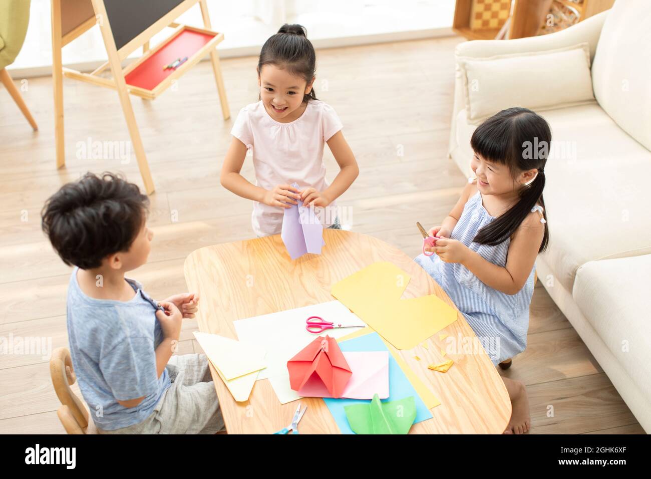 Cute children doing paper craft in living room Stock Photo - Alamy