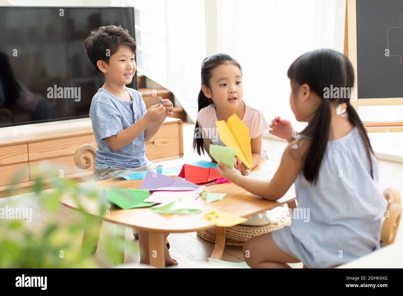Cute children doing paper craft in living room Stock Photo - Alamy