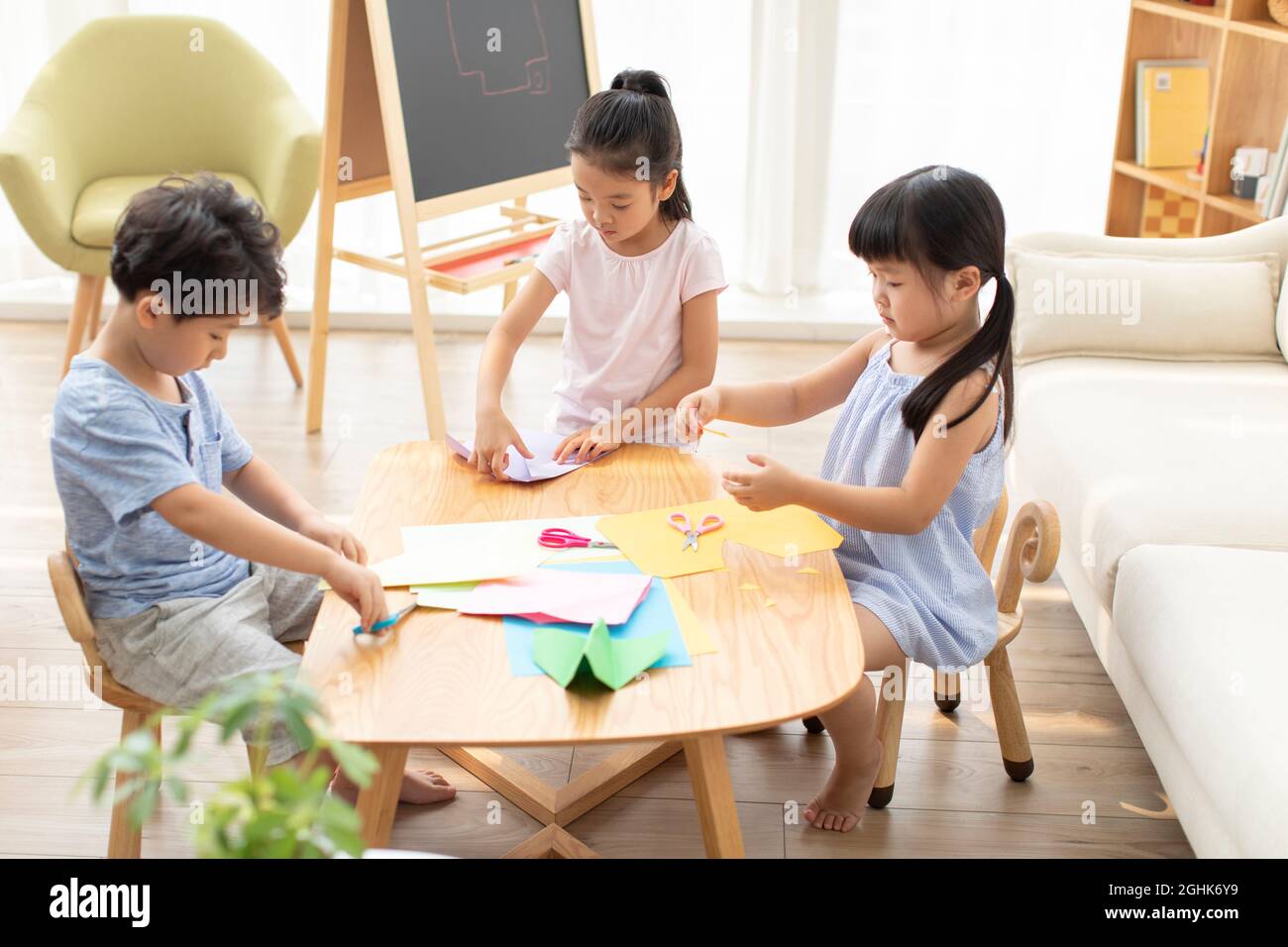 Cute children doing paper craft in living room Stock Photo - Alamy