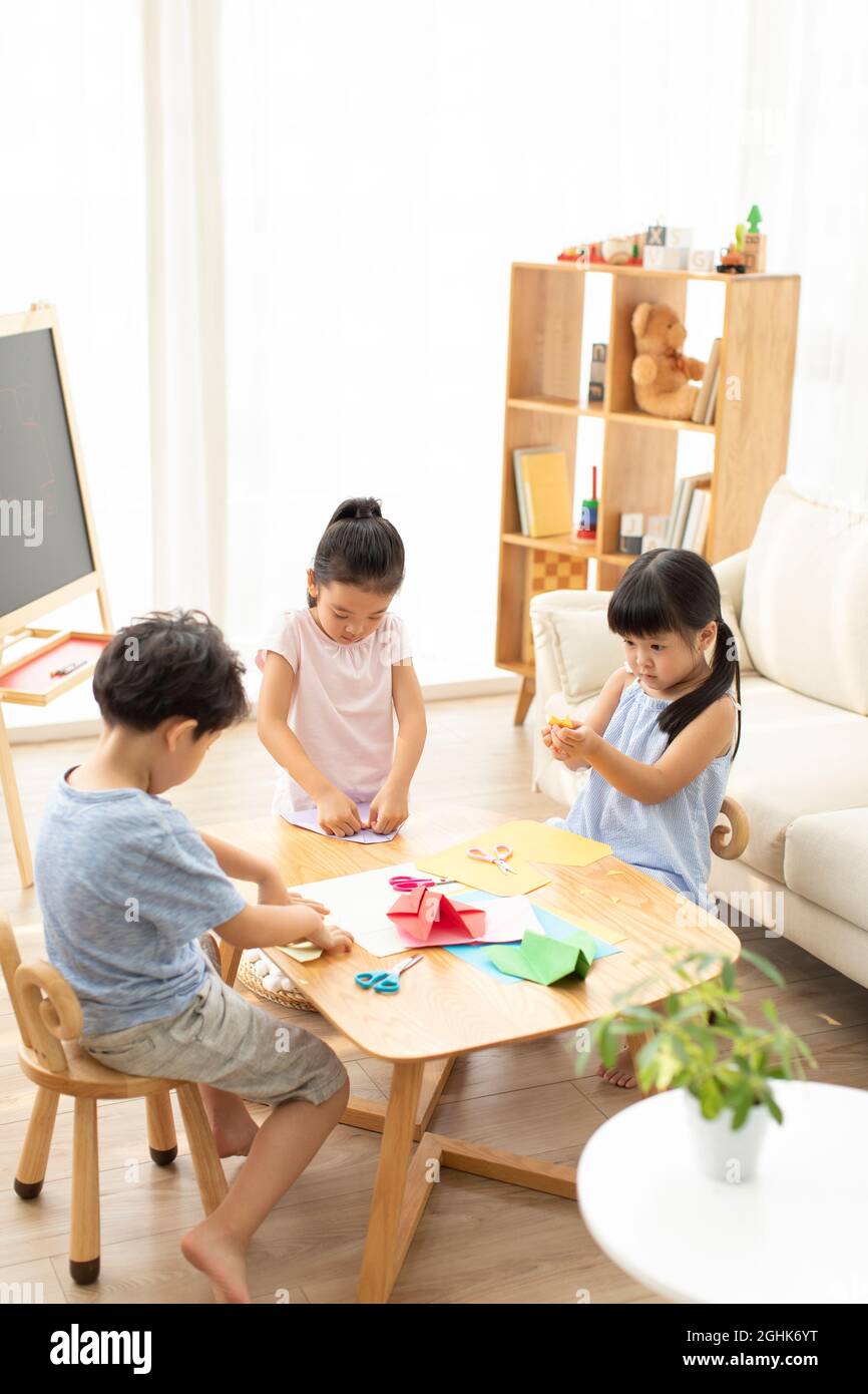 Cute children doing paper craft in living room Stock Photo - Alamy