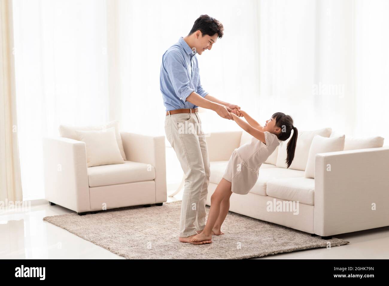 Happy father and daughter relaxing in living room Stock Photo - Alamy