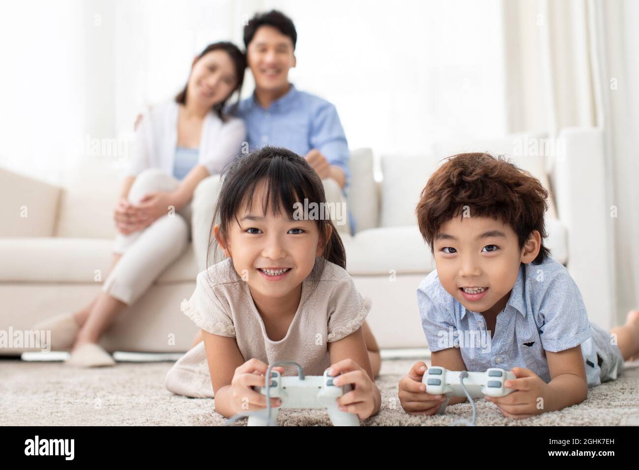 Cute sibling playing video game at home Stock Photo - Alamy