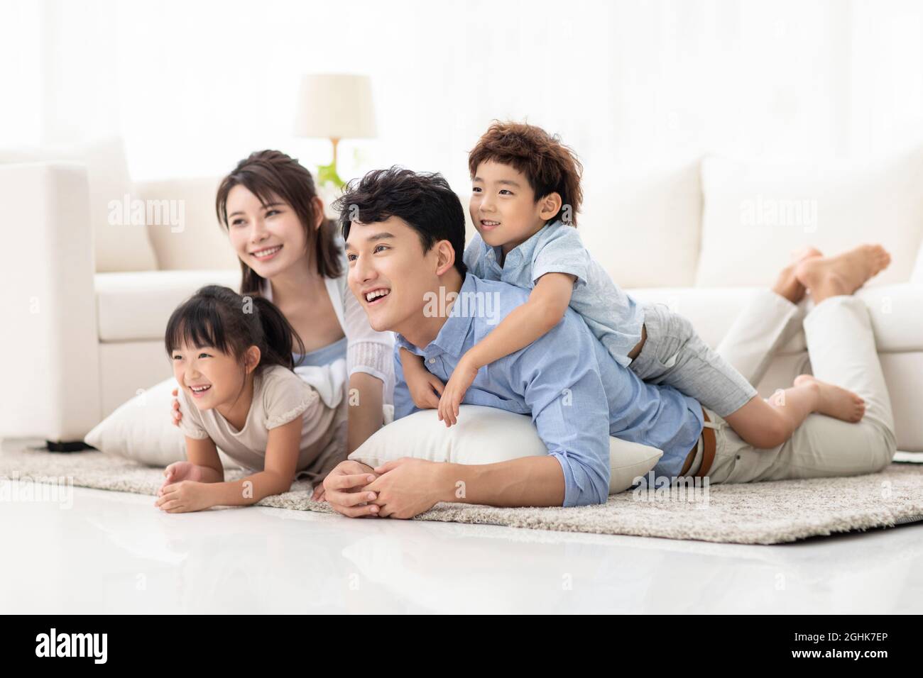 Happy family relaxing in living room Stock Photo - Alamy