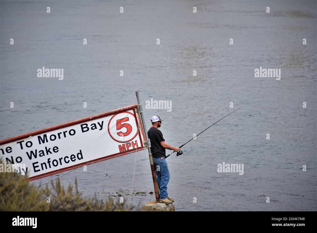 People fishing at the entrance to Morro Bay, with the decommissioned ...