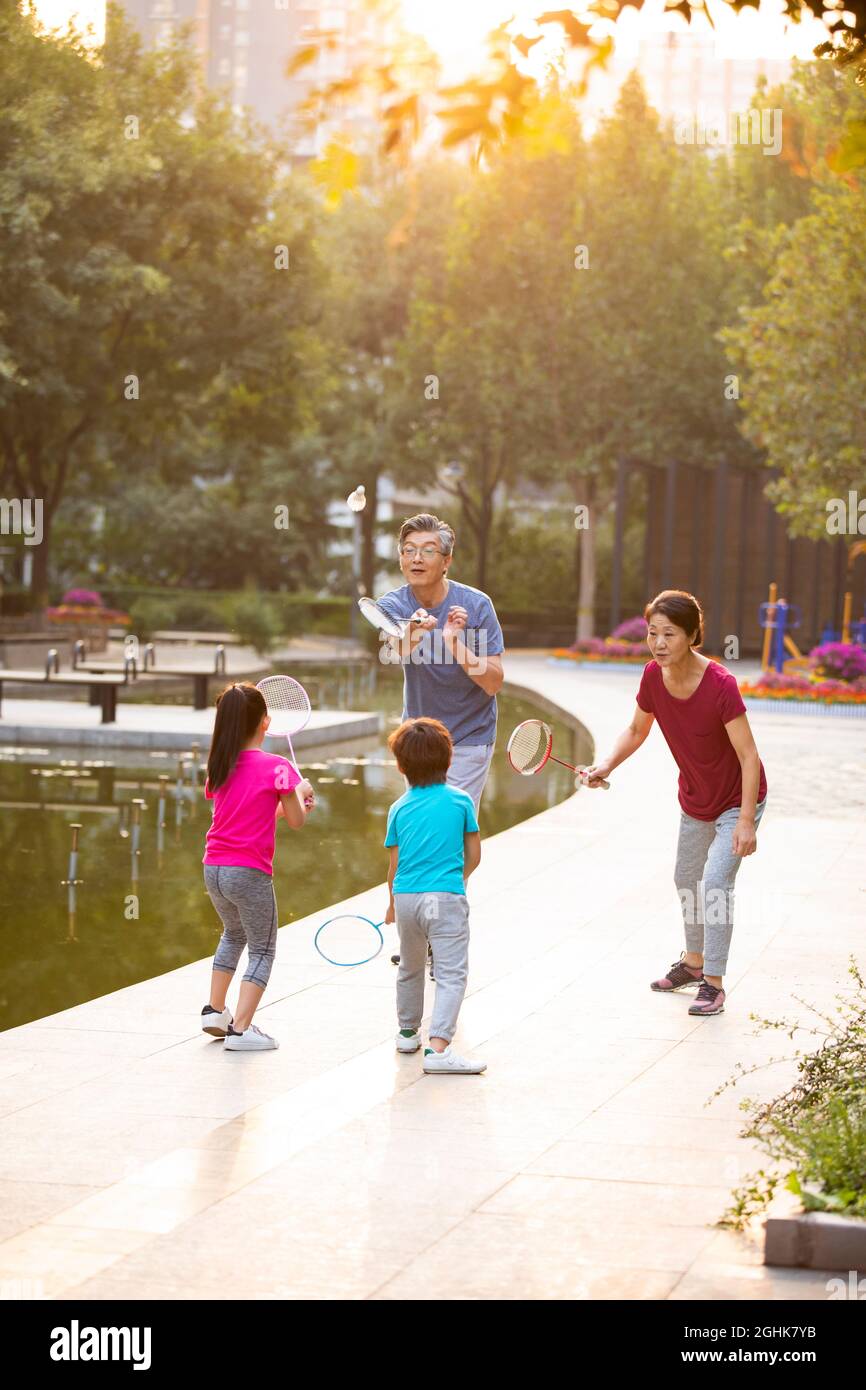 Happy family playing badminton in park Stock Photo - Alamy
