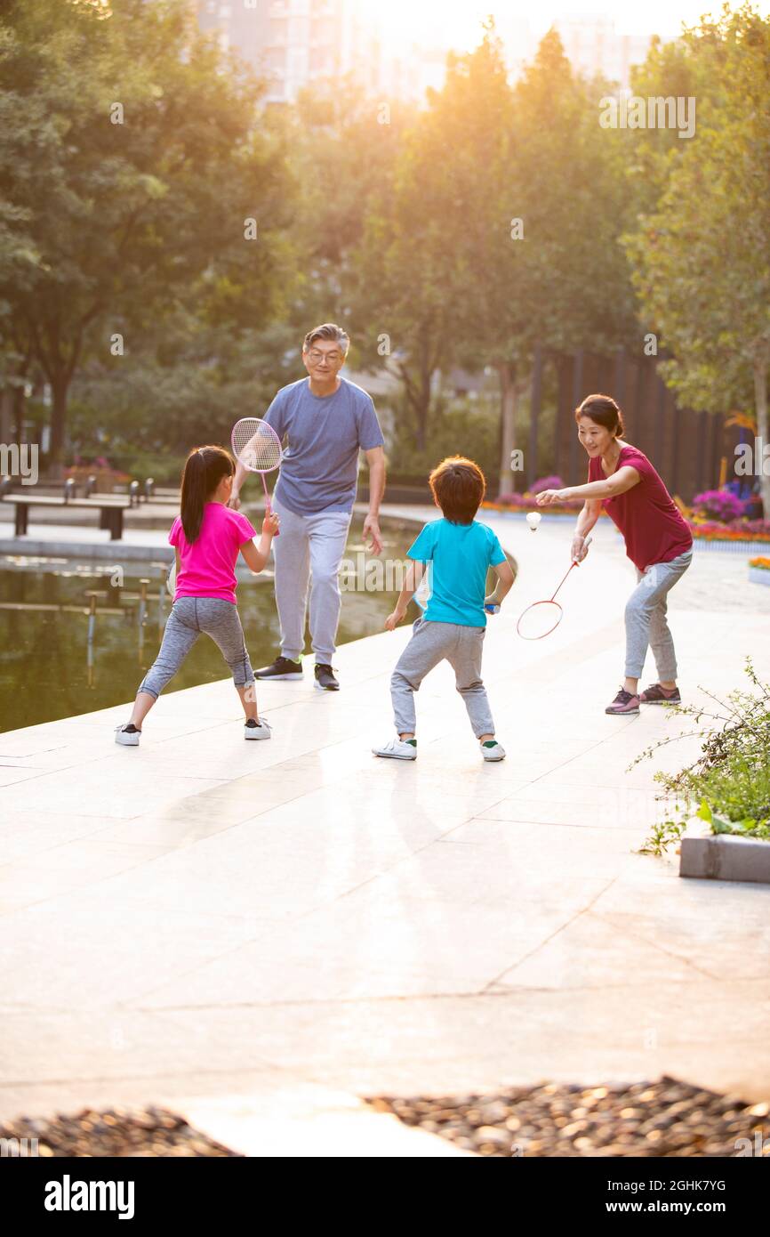 Happy family playing badminton in park Stock Photo - Alamy