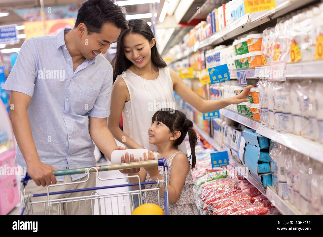 Happy young family shopping in supermarket Stock Photo - Alamy