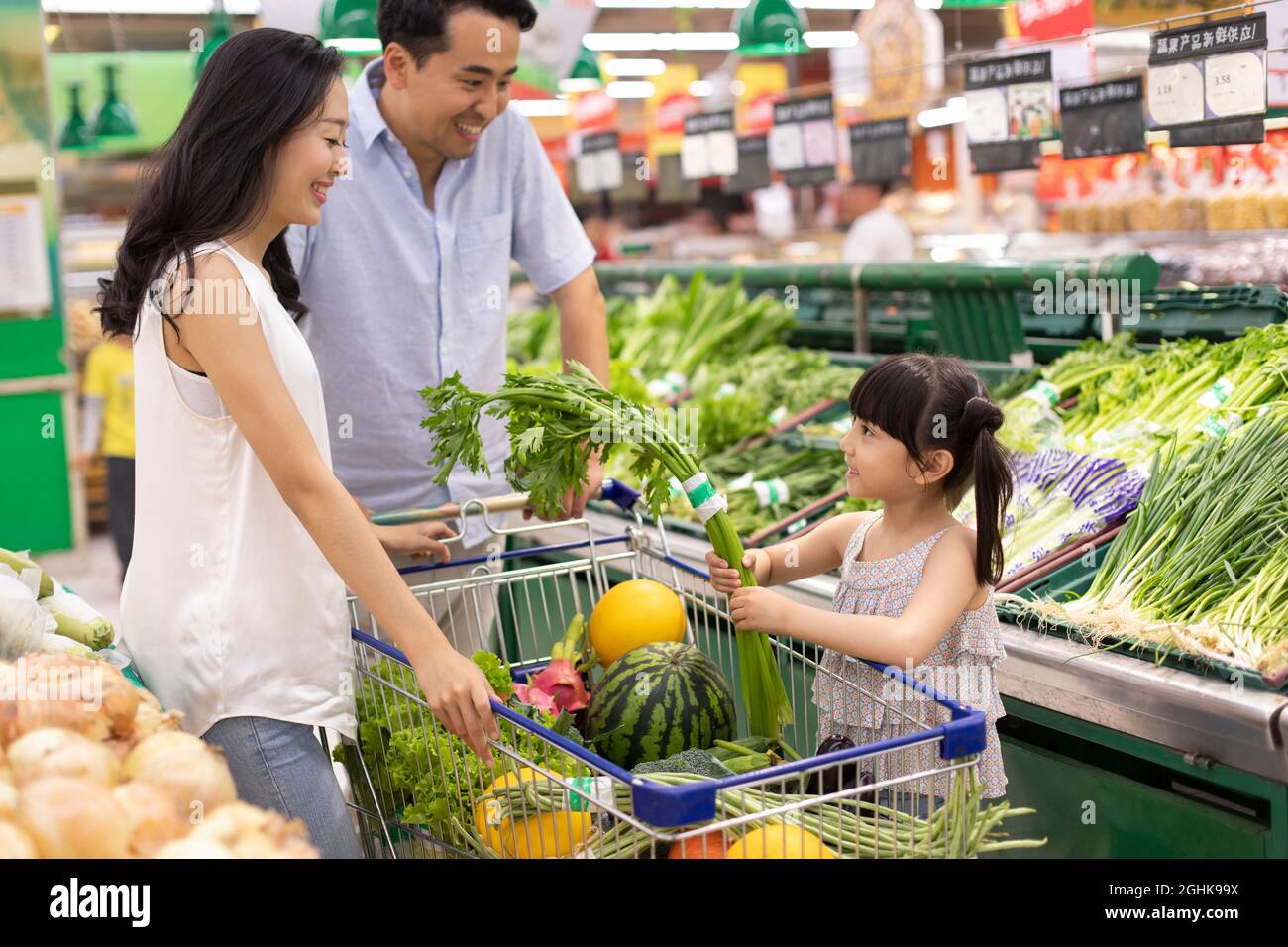 Happy young family shopping in supermarket Stock Photo - Alamy