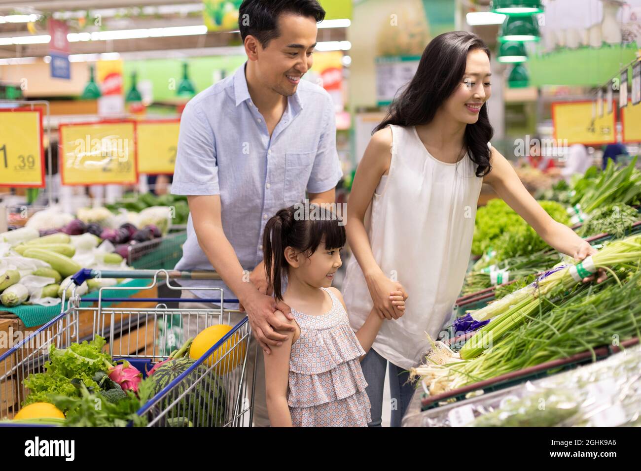 Happy young family shopping in supermarket Stock Photo - Alamy