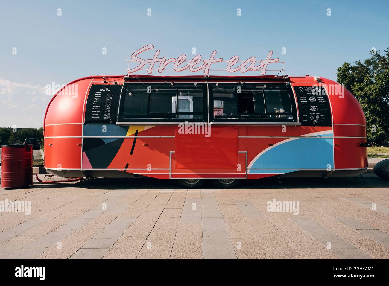 Red long food track selling fast food in the middle of street or square ...