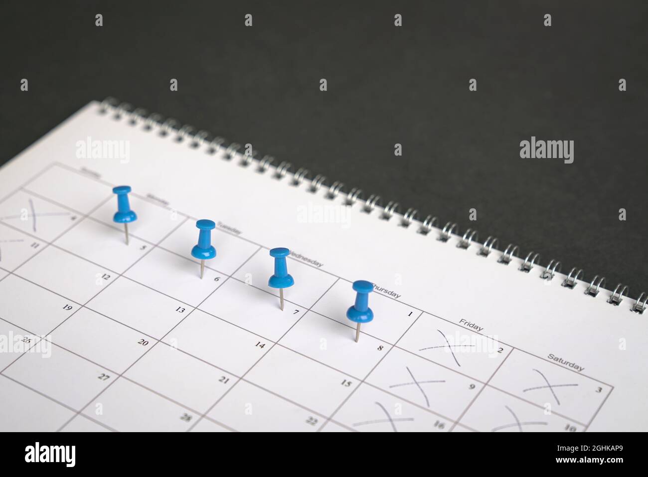 Blue pins on four days in a week on a calendar. Friday, Saturday and ...