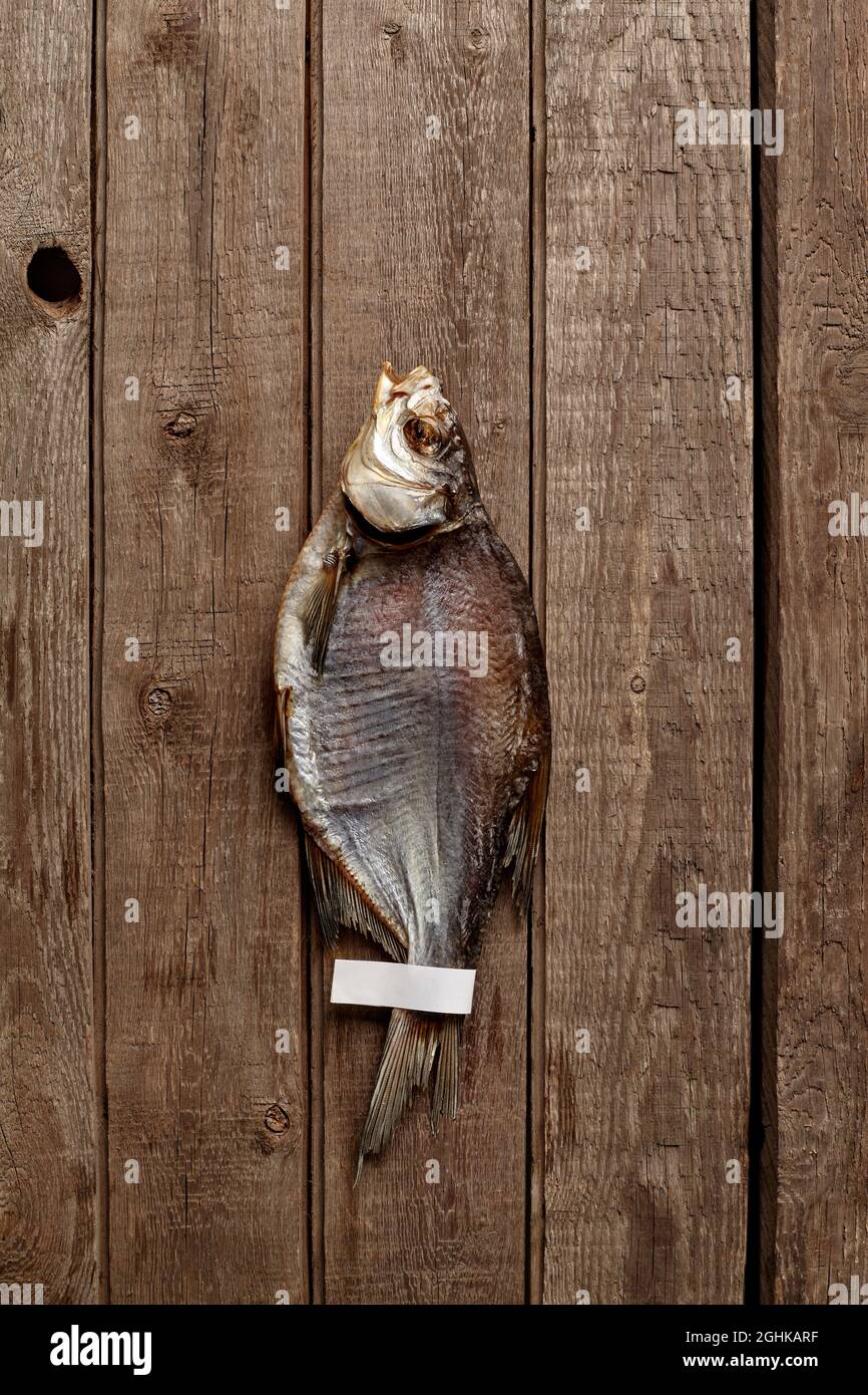 Sun-dried bream with paper label on tail on wooden background Stock ...