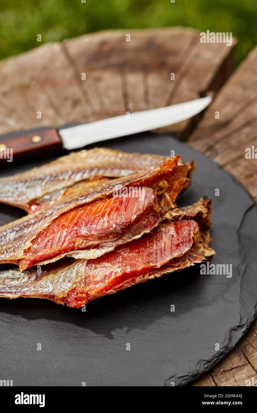 Salted sun-dried roach with roe and knife on slate serving board Stock ...