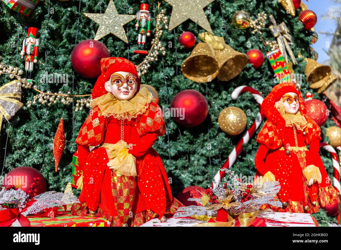 Two christmas elfs dressed in red, with christmas tree decorations in ...