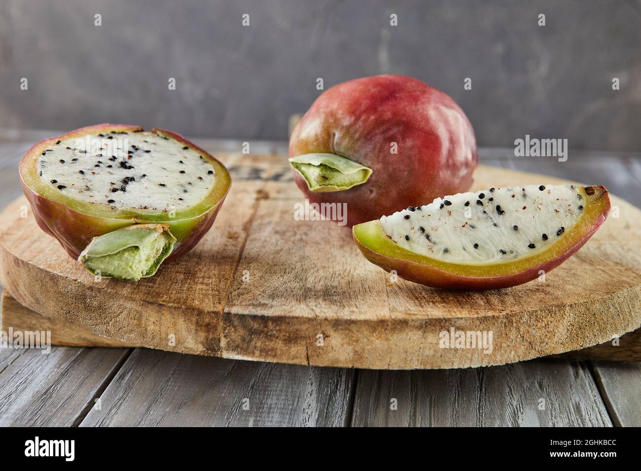 Peruvian apple cactus fruits whole and cut on wooden stand on gray ...