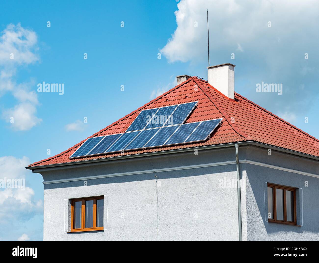 Electric solar panels on the tiled roof of family house. The insulated ...