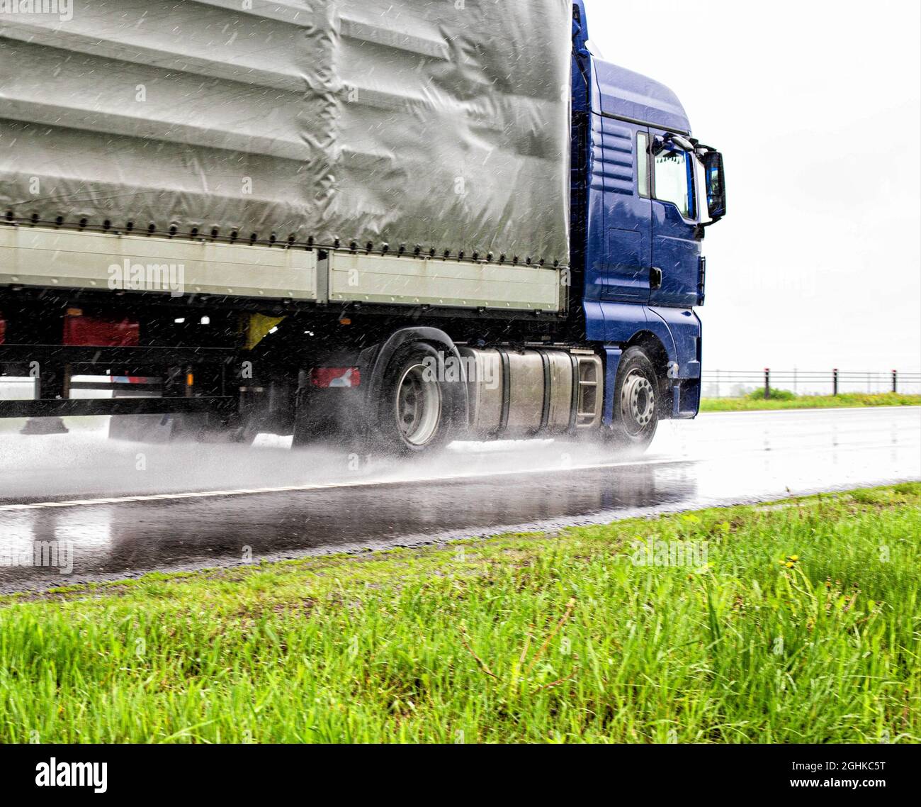 Semi-trailer semitrailer transports cargo on a wet road from rain in ...