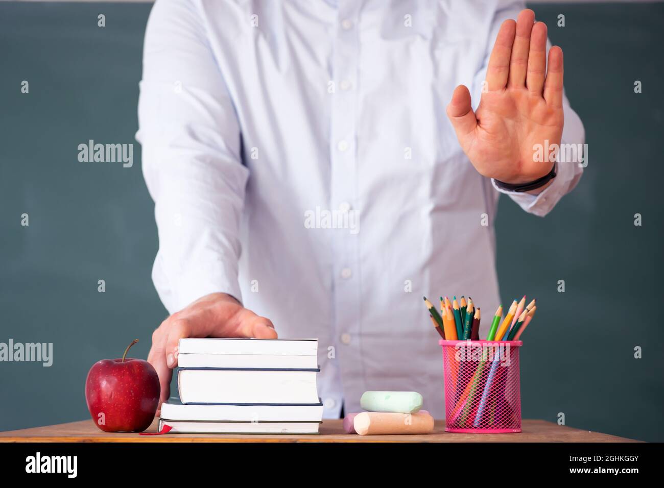 Back to school concept: teacher giving books to her studens in the ...