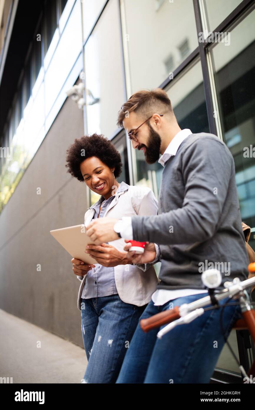 Business people discussing and smiling while walking together outdoor ...