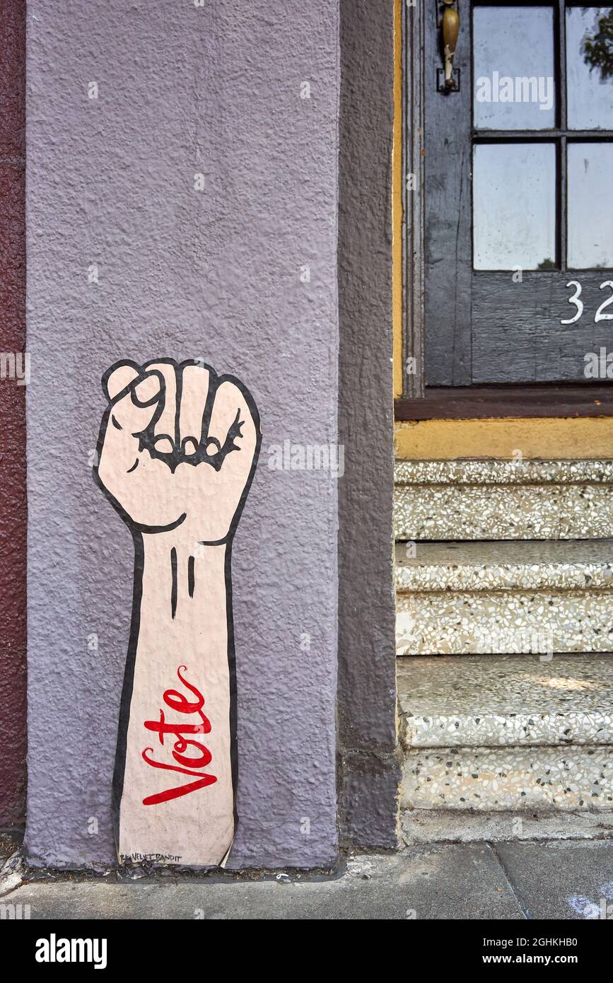 Artwork of arm pointing up and Vote written on it on a wall near front ...