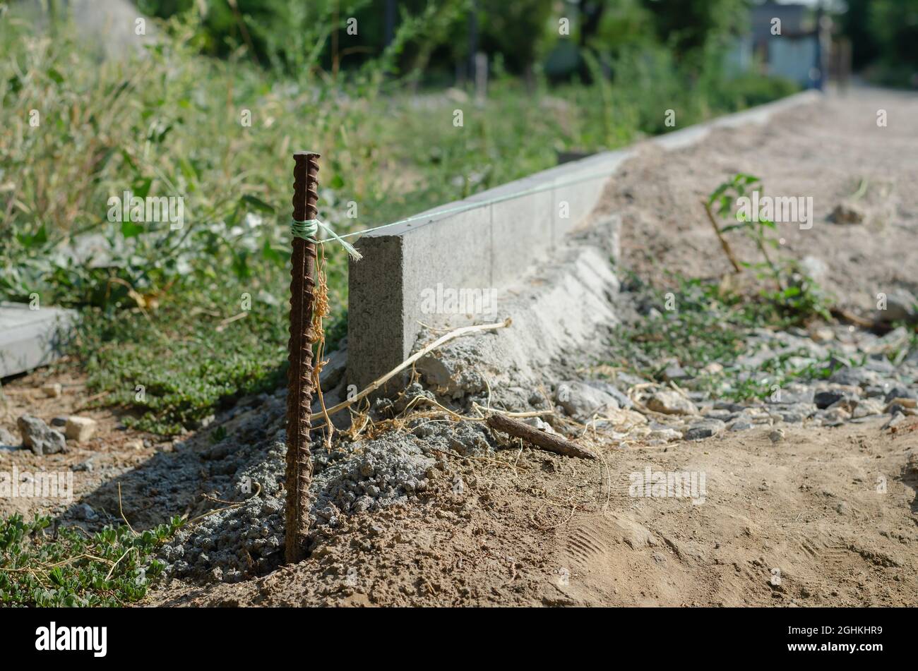 A bar of rebar vertically with a rope tied at the construction site ...