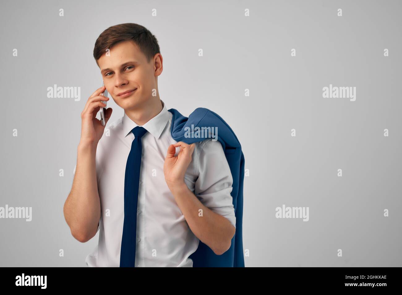 business man with a jacket on his shoulder with a phone communication ...