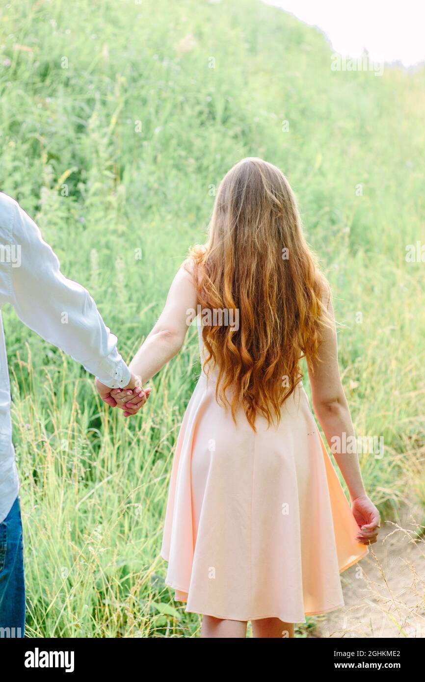 Young lovely girl leading a man by a hand Stock Photo - Alamy