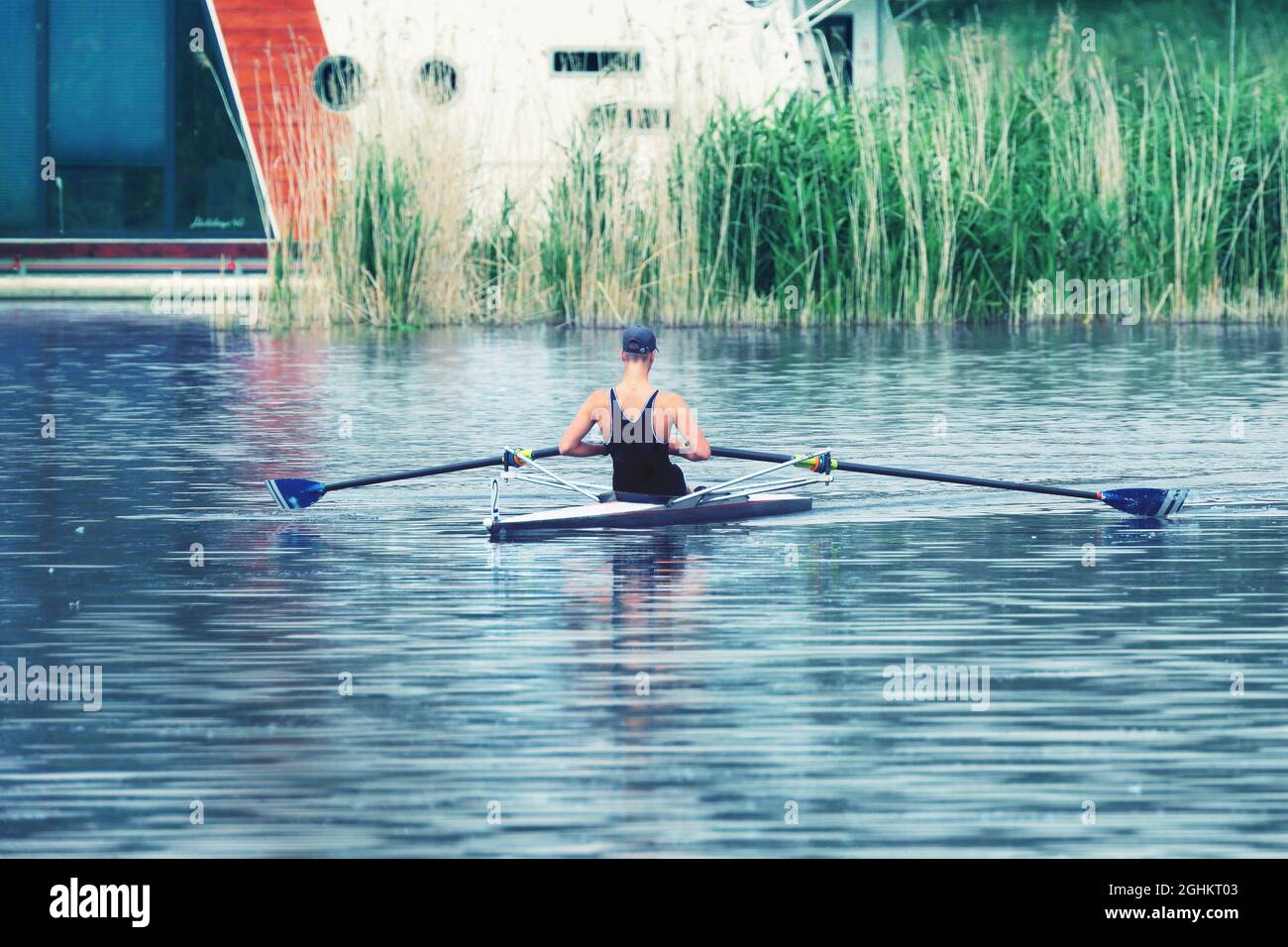 Young man rowing a boat near the seaside Stock Photo - Alamy