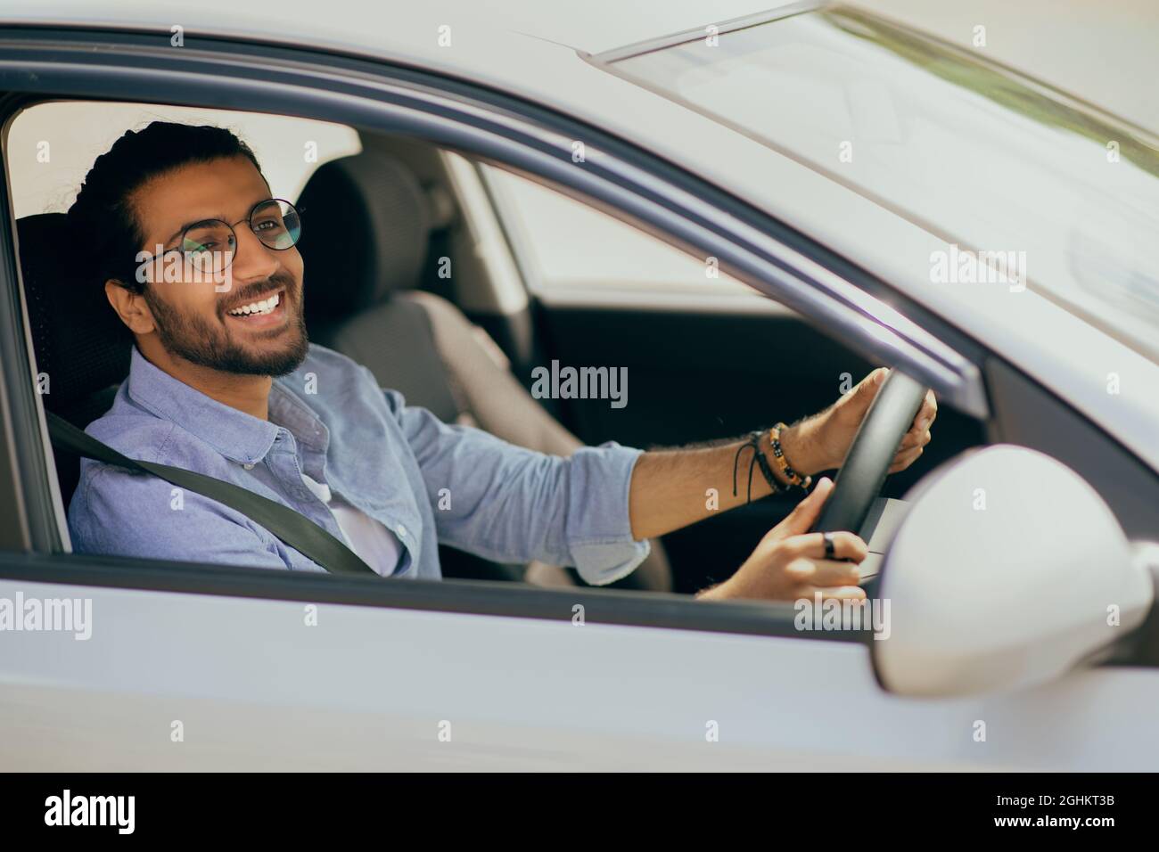 Happy millennial middle-eastern guy driving auto, side view Stock Photo ...
