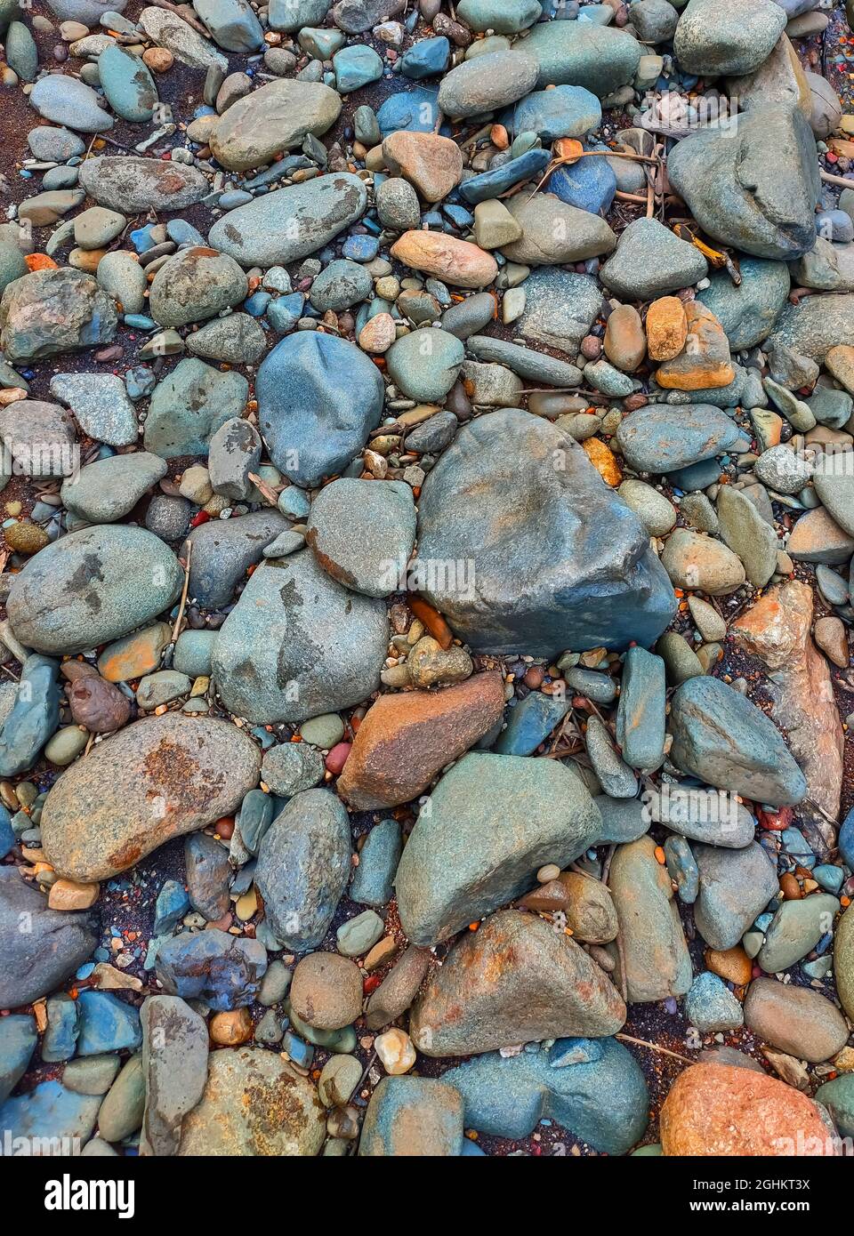 Closeup of the colorful differently shaped rocks on the sandy ground on ...